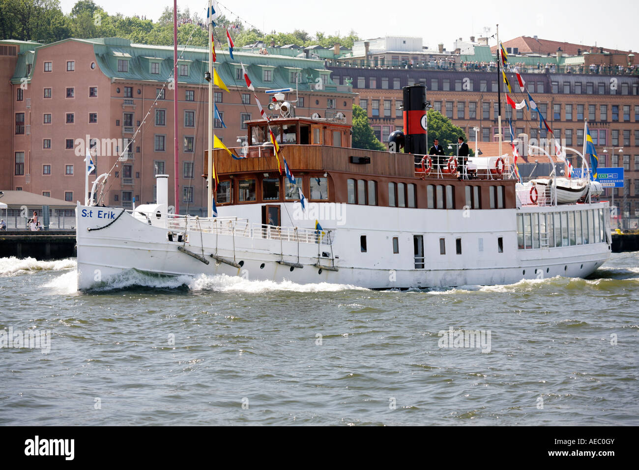 Old timer passenger boat in full speed through canal with residential ...