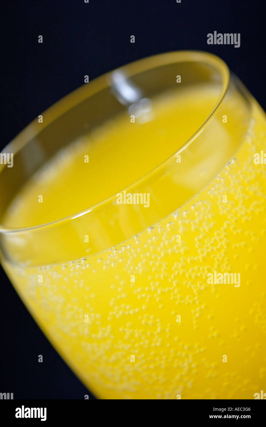 Close up of fizzy orange drink in glass against black background Stock ...