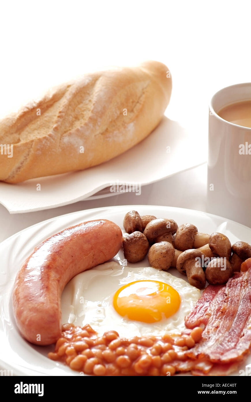 Traditional English Cooked Breakfast of Sausage Egg Bacon Mushrooms and ...