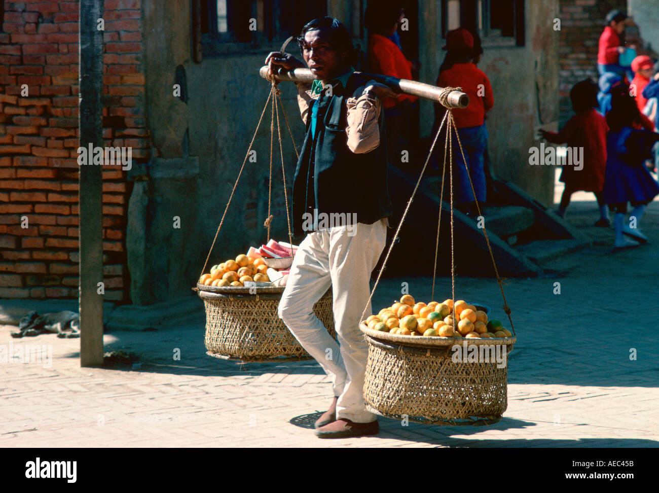 Fruit seller carrying fruits in baskets on shoulder hoist Bhaktapur ...