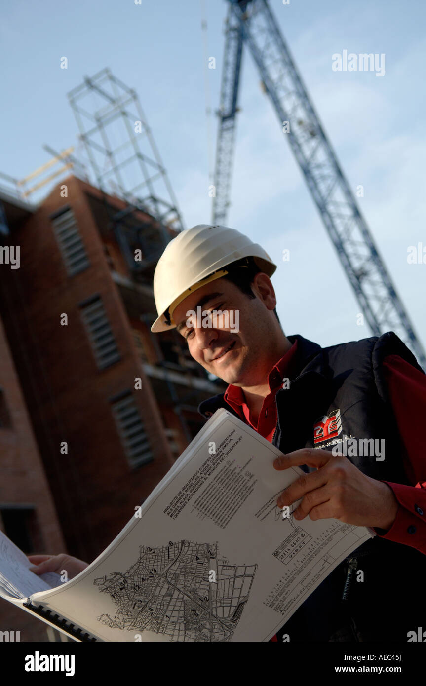 Construction worker looking at building plans Stock Photo - Alamy