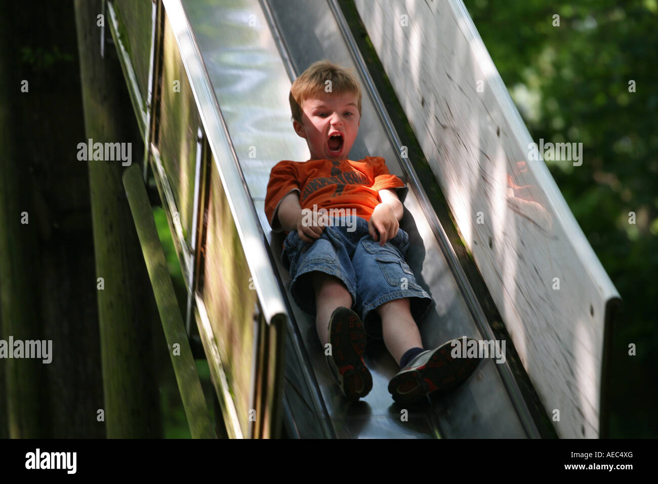 Boy sliding down a slide Stock Photo - Alamy