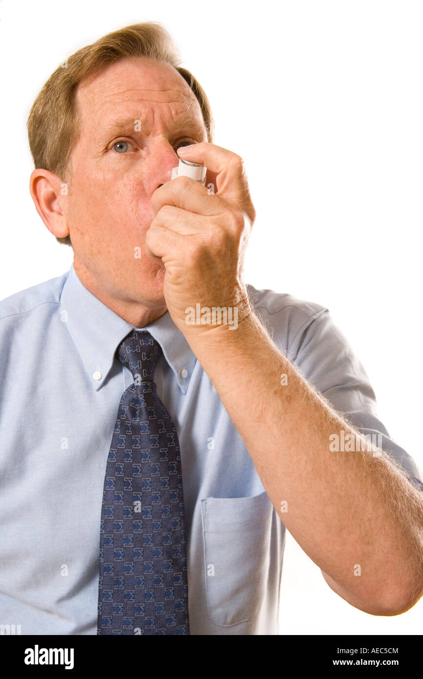 Middle aged man using Inhaler to deliver medication Stock Photo - Alamy