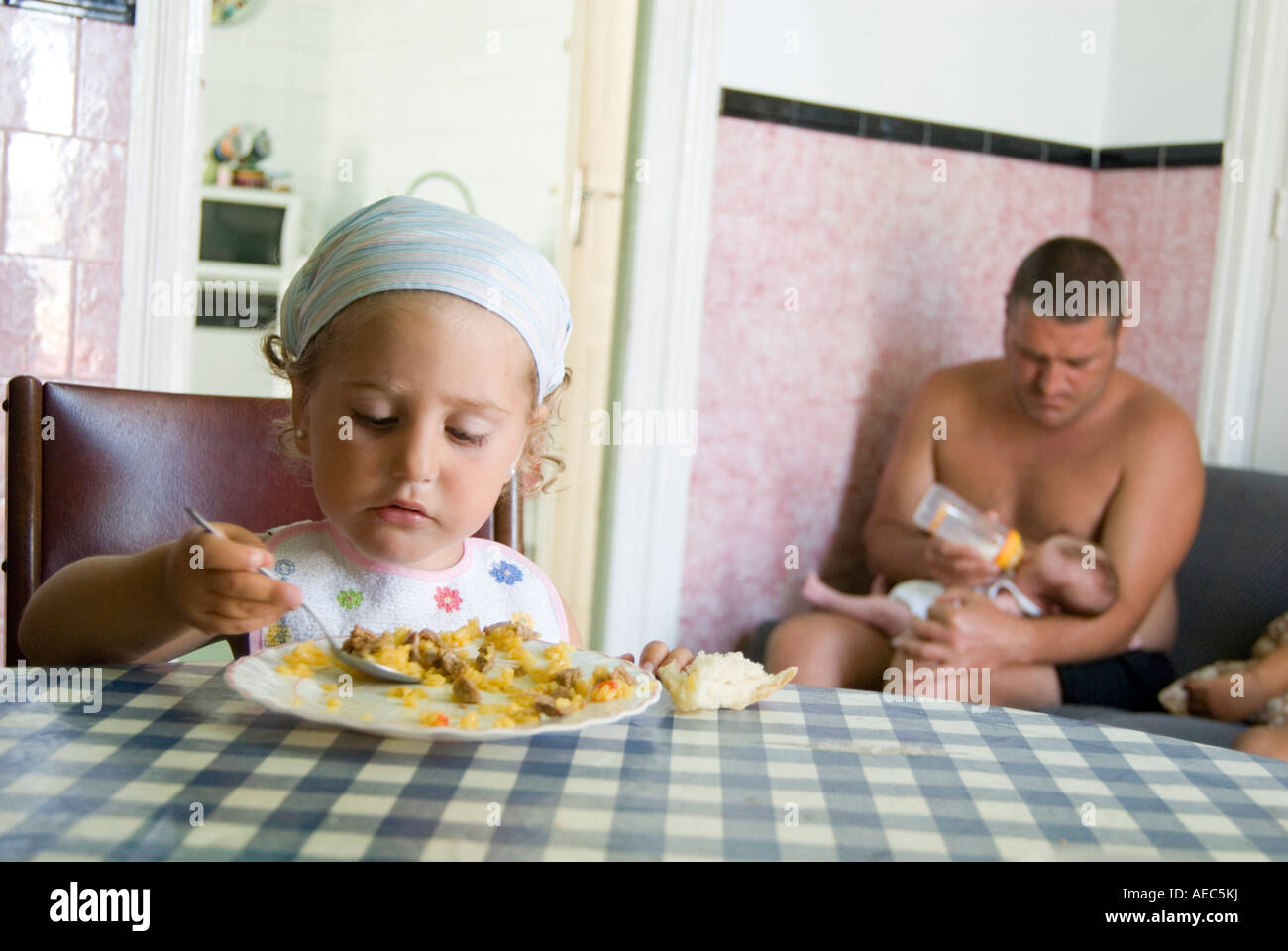 Small Child Eating At The Lunch Table While Father Bottle Feeds Baby Spain Stock Photo Alamy small-child-eating-at-the-lunch-table-while-father-bottle-feeds-baby-spain-stock-photo-alamy