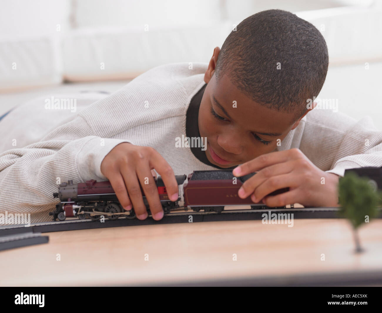 African boy playing with model train on floor Stock Photo - Alamy