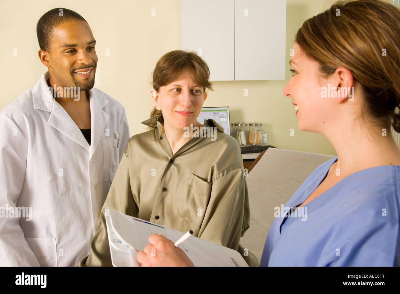 Medical team with patient in exam room delivering good news Stock Photo ...