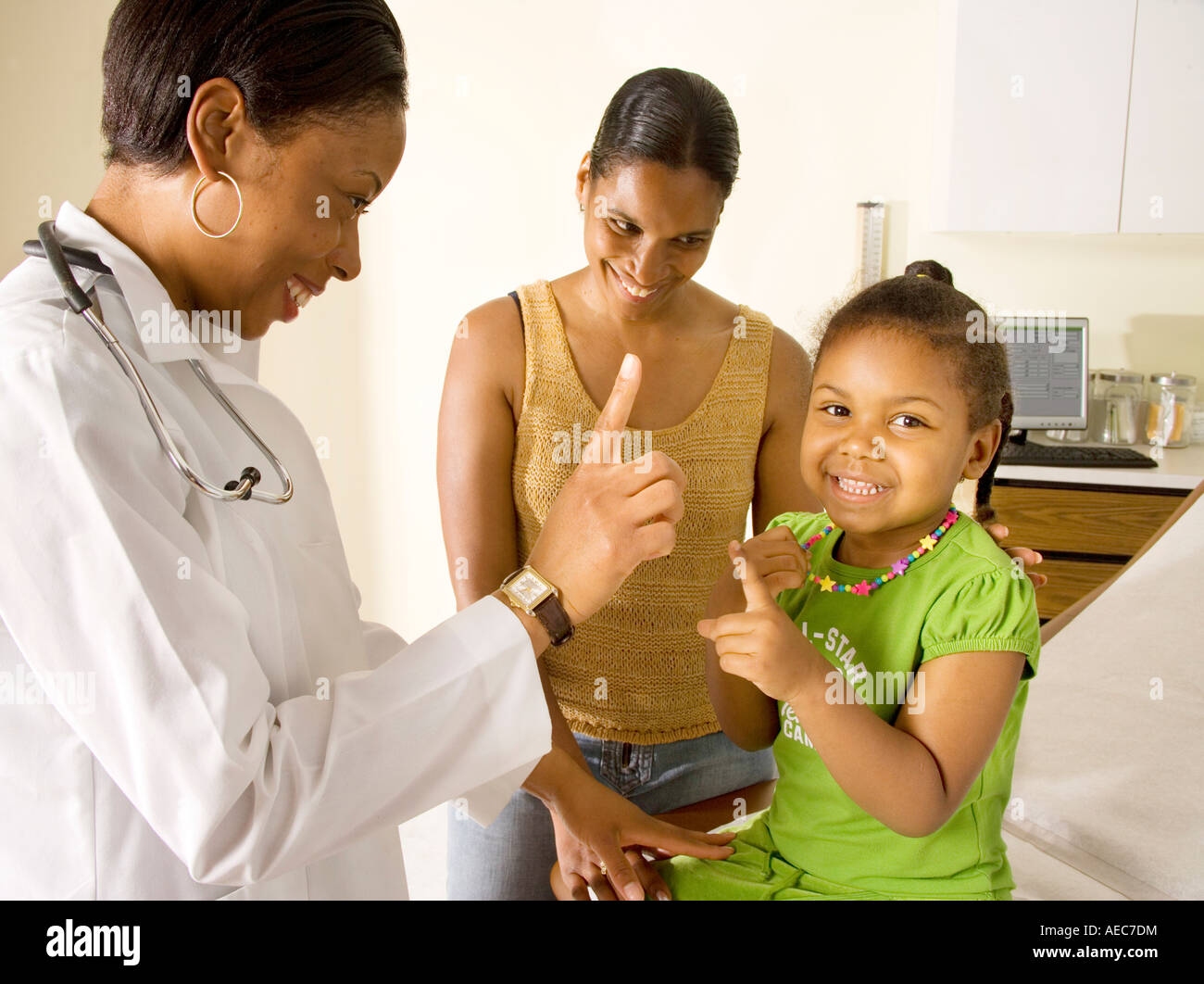 African American doctor examines little girl with Mom in the room Stock ...