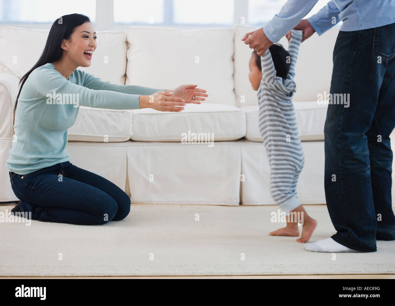 Asian parents helping baby walk Stock Photo - Alamy