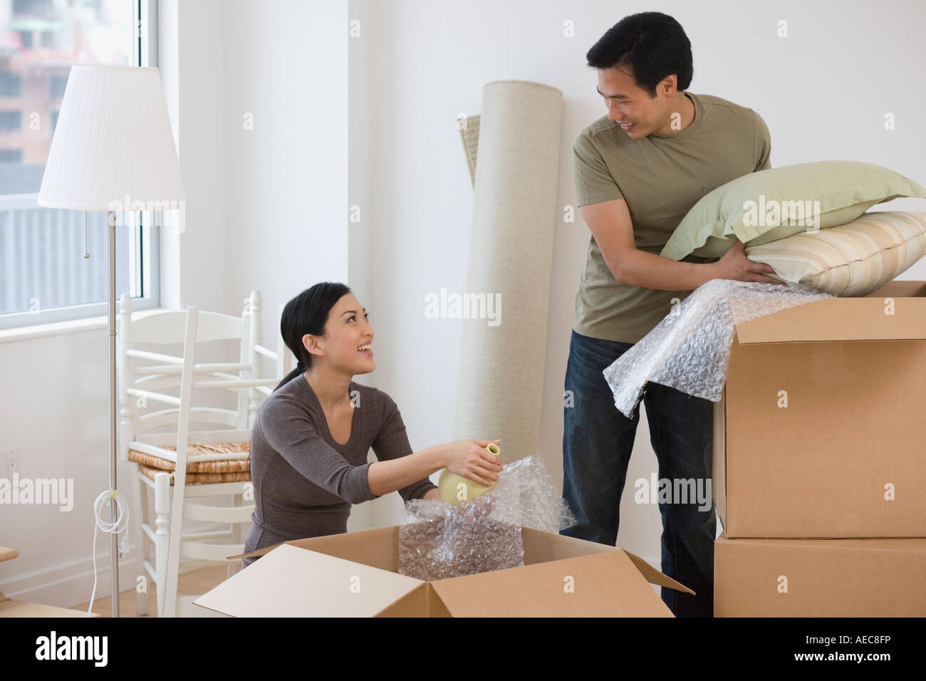 Asian couple unpacking boxes Stock Photo - Alamy