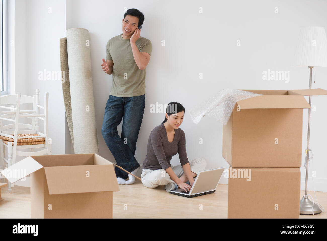 Asian couple taking break from moving Stock Photo - Alamy