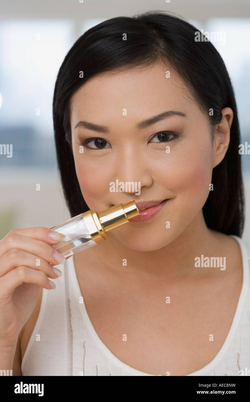 Asian woman smelling perfume Stock Photo - Alamy