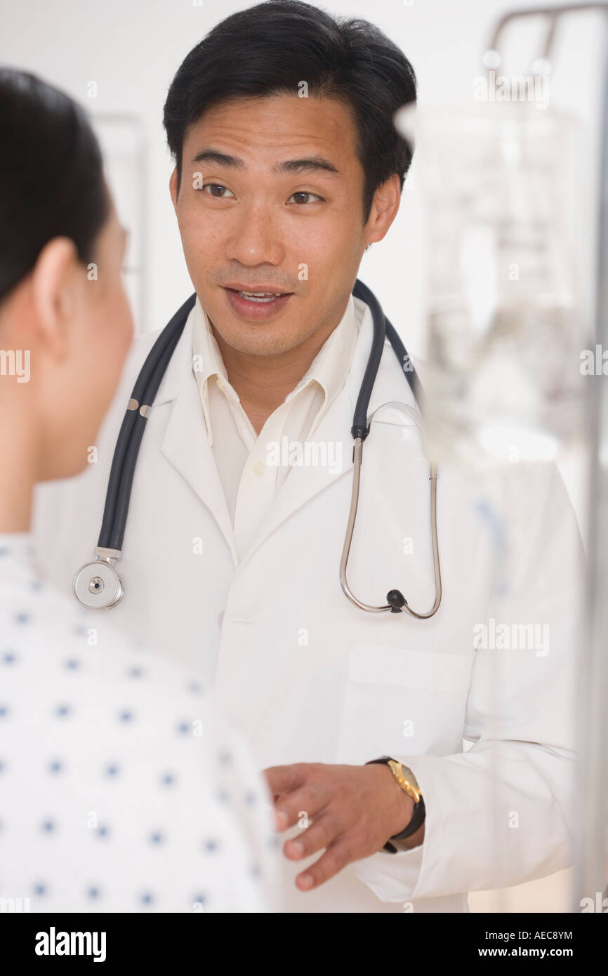 Asian male doctor talking to patient Stock Photo - Alamy