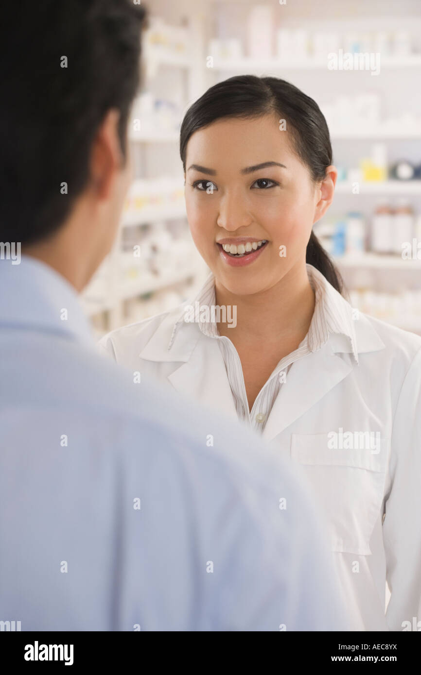 Asian female pharmacist talking to customer Stock Photo - Alamy