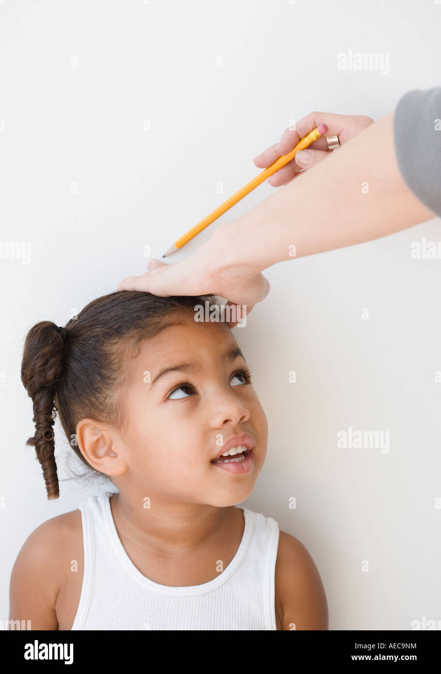 Adult measuring African girl's height Stock Photo - Alamy