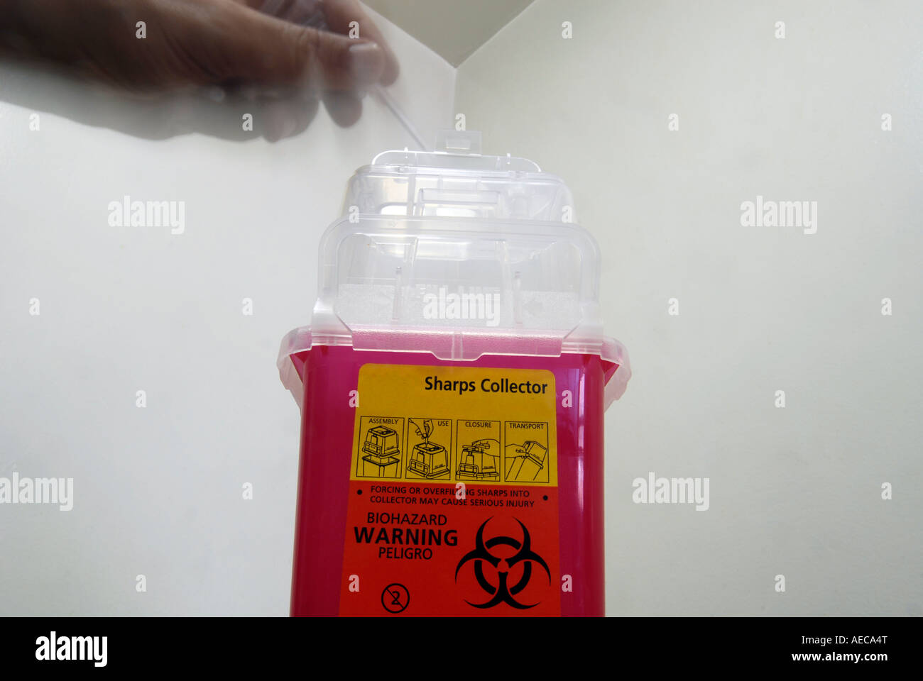 Placing a used needle into a sharps collection container Stock Photo ...