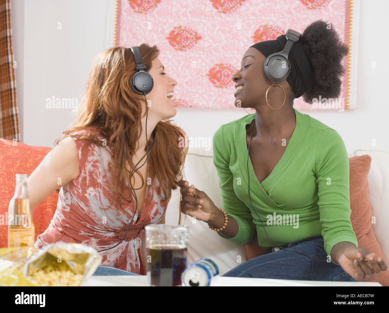 Two women singing to headphones Stock Photo - Alamy