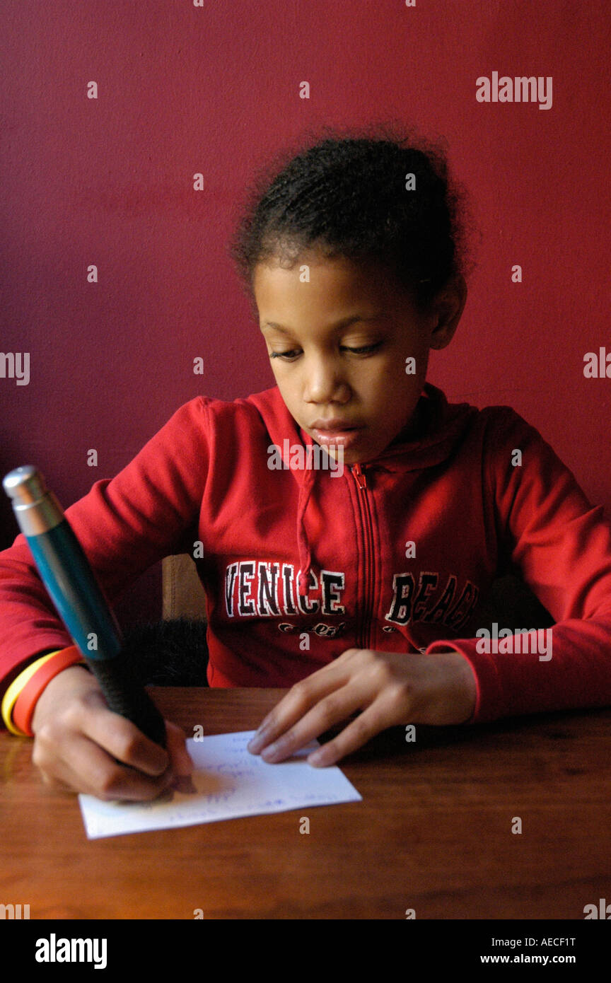 Young Mixed race girl writing Stock Photo - Alamy