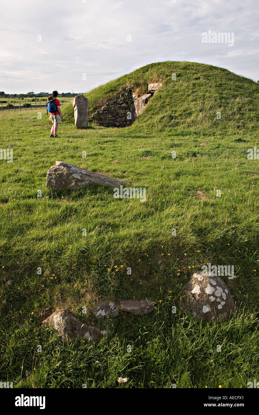 Walker at entrance to the ancient burial mound of Bryn Celli Ddu with ...