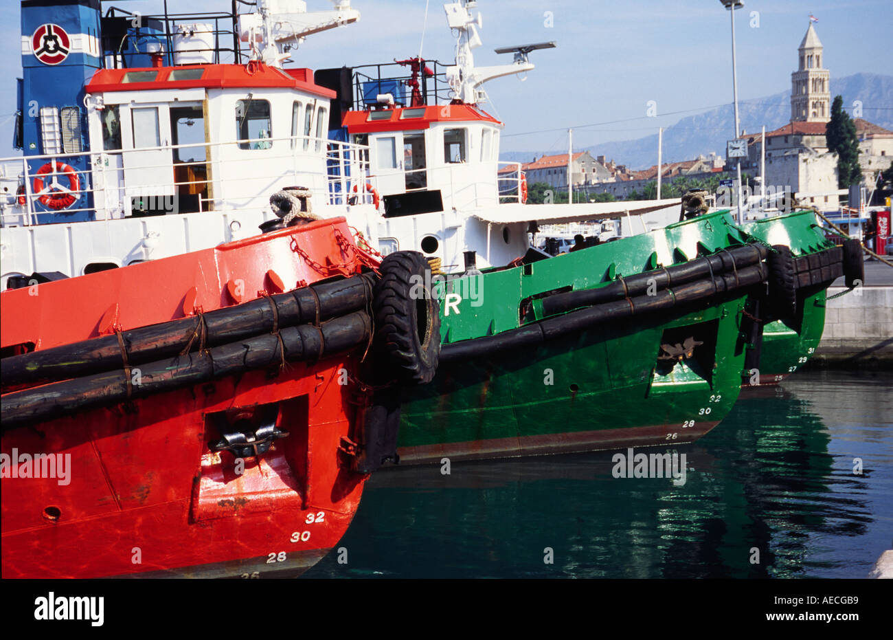 A green and red coloured tugboat at dock in the harbour of Split ...