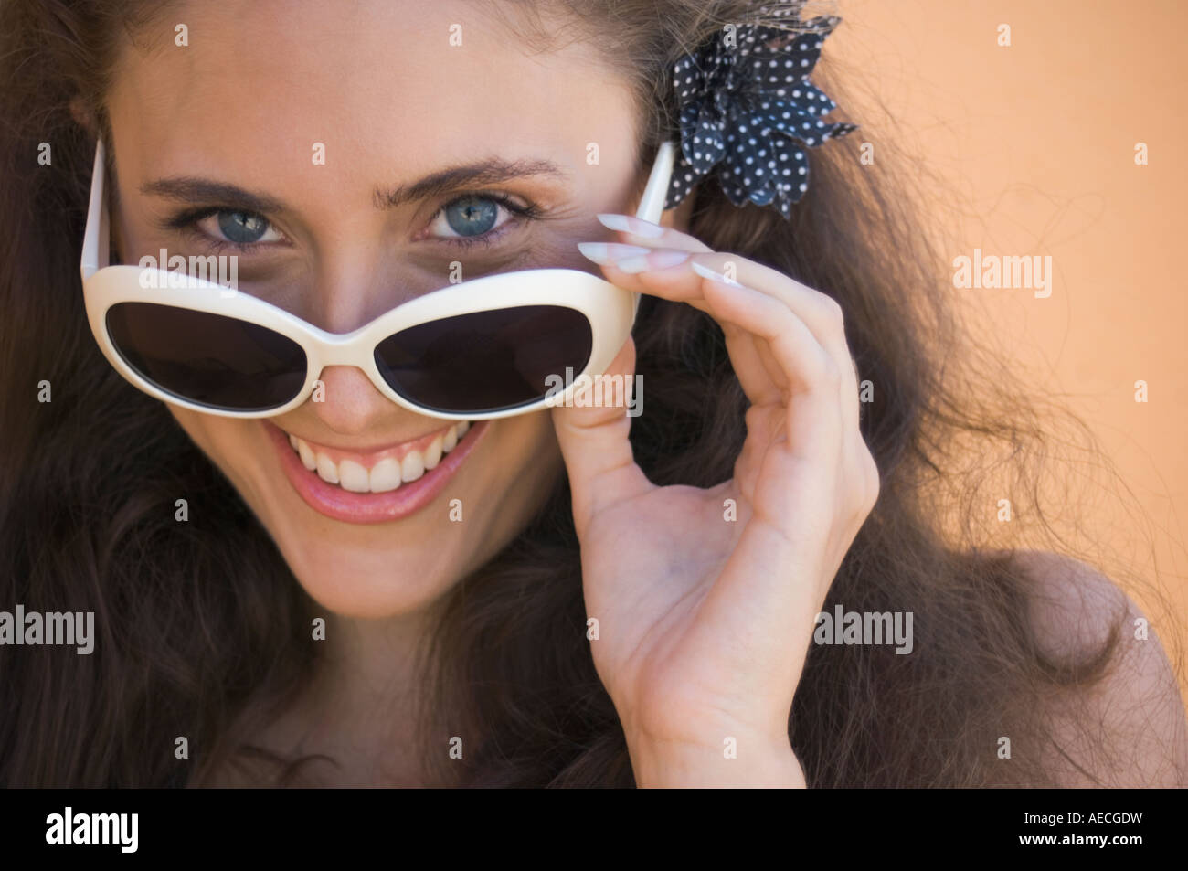 Woman peeking over sunglasses hi-res stock photography and images - Alamy