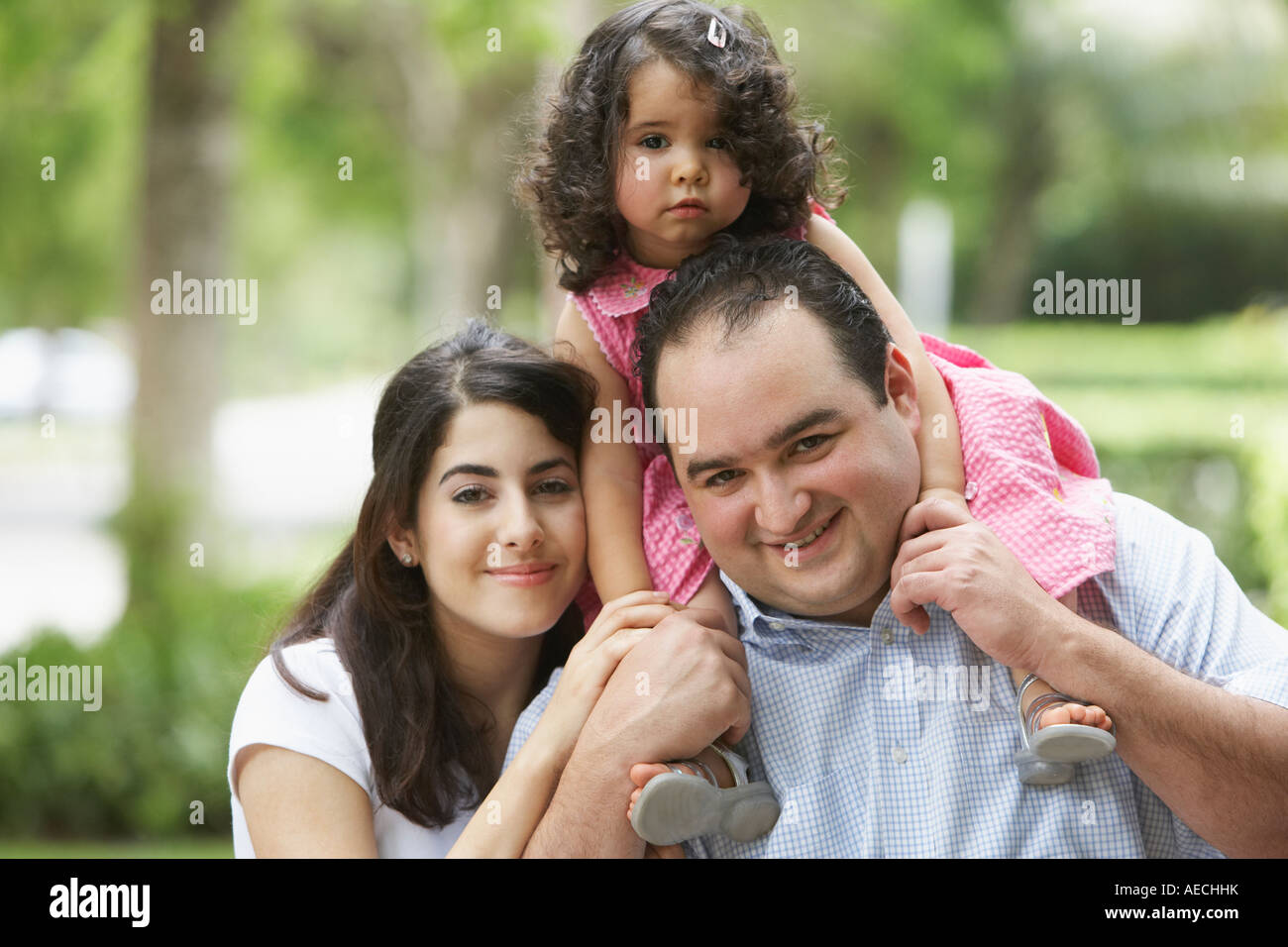 Hispanic father and mother with daughter on shoulders Stock Photo - Alamy