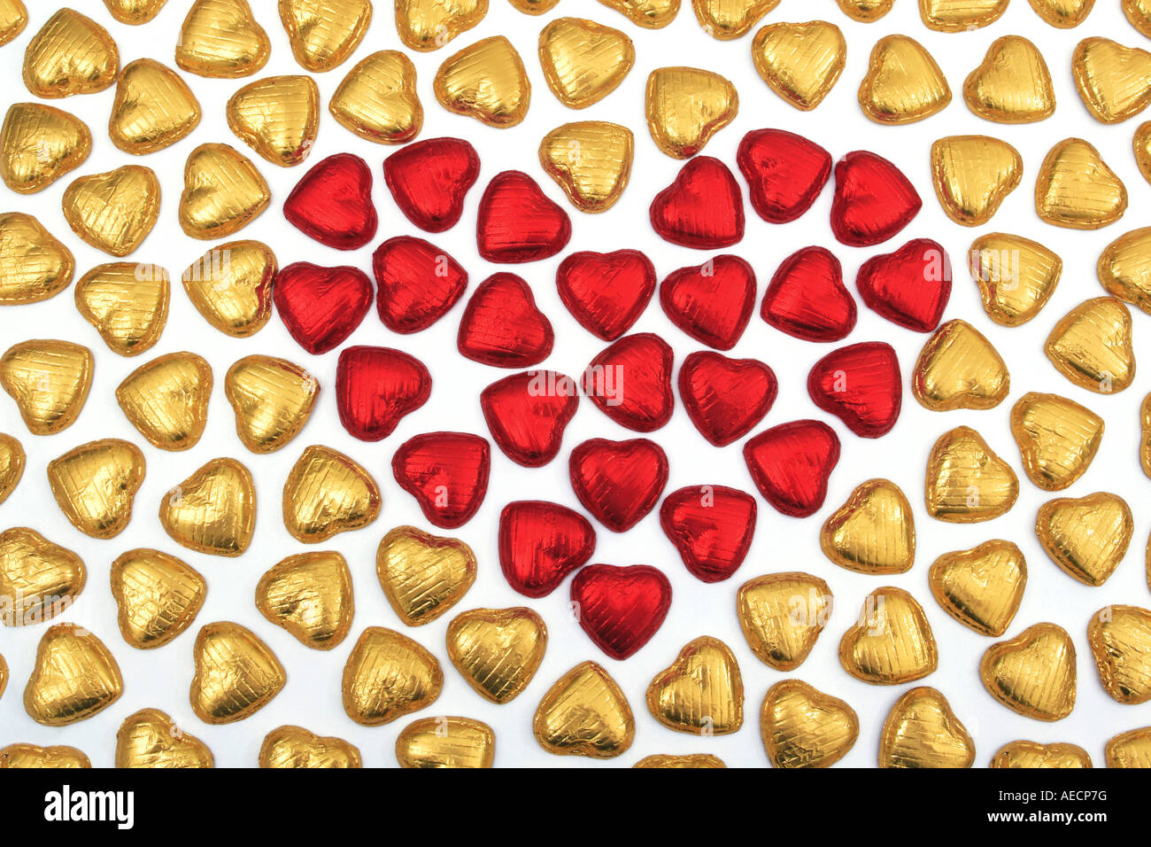 heart out of red chocolate hearts surrounded with many golden chocolate ...
