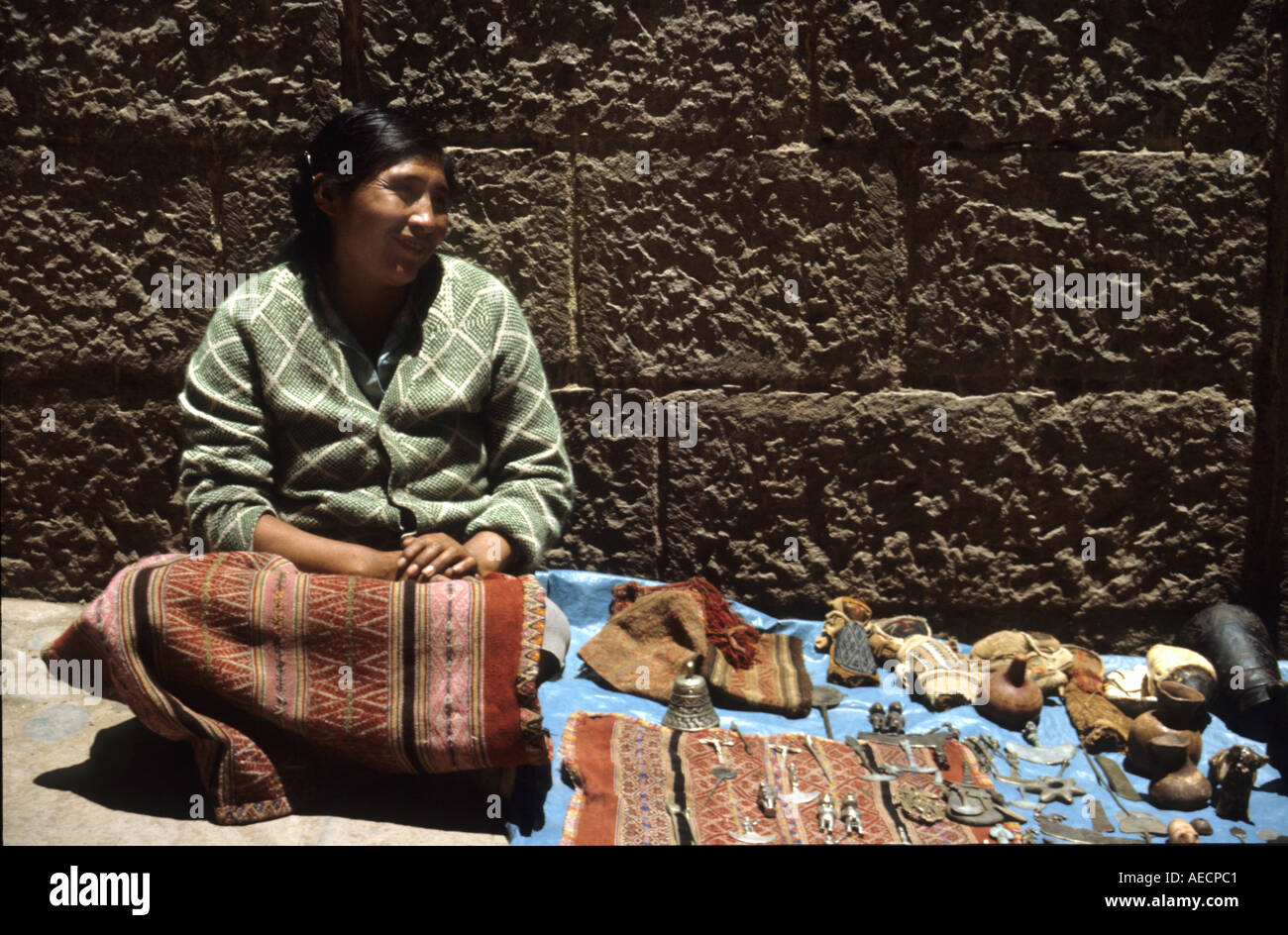 Indian women sells crafts in front of Incan wall Stock Photo - Alamy