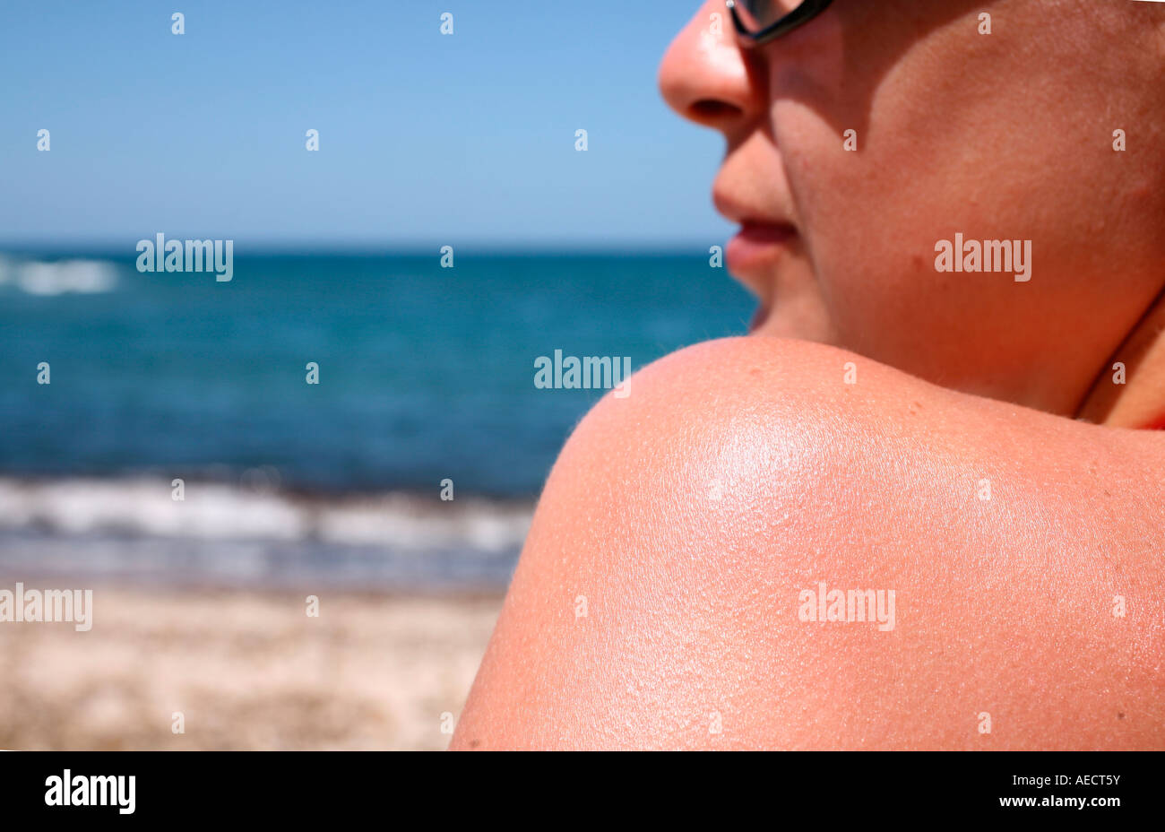 Woman sat on beach looking over shoulder Stock Photo - Alamy