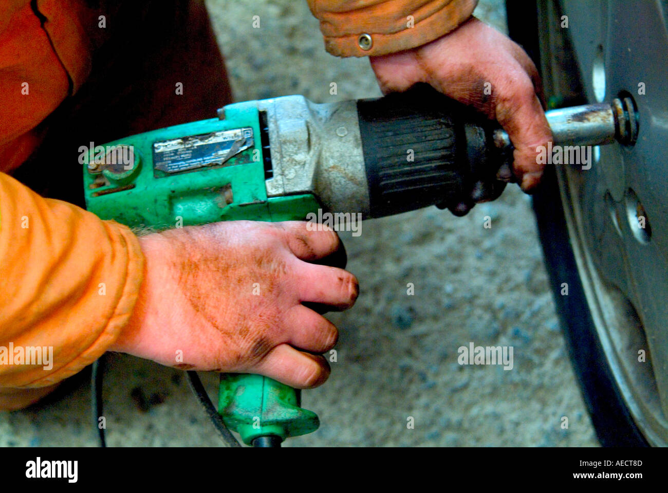 mechanic using power tools to take wheel nuts of car wheel Stock Photo ...