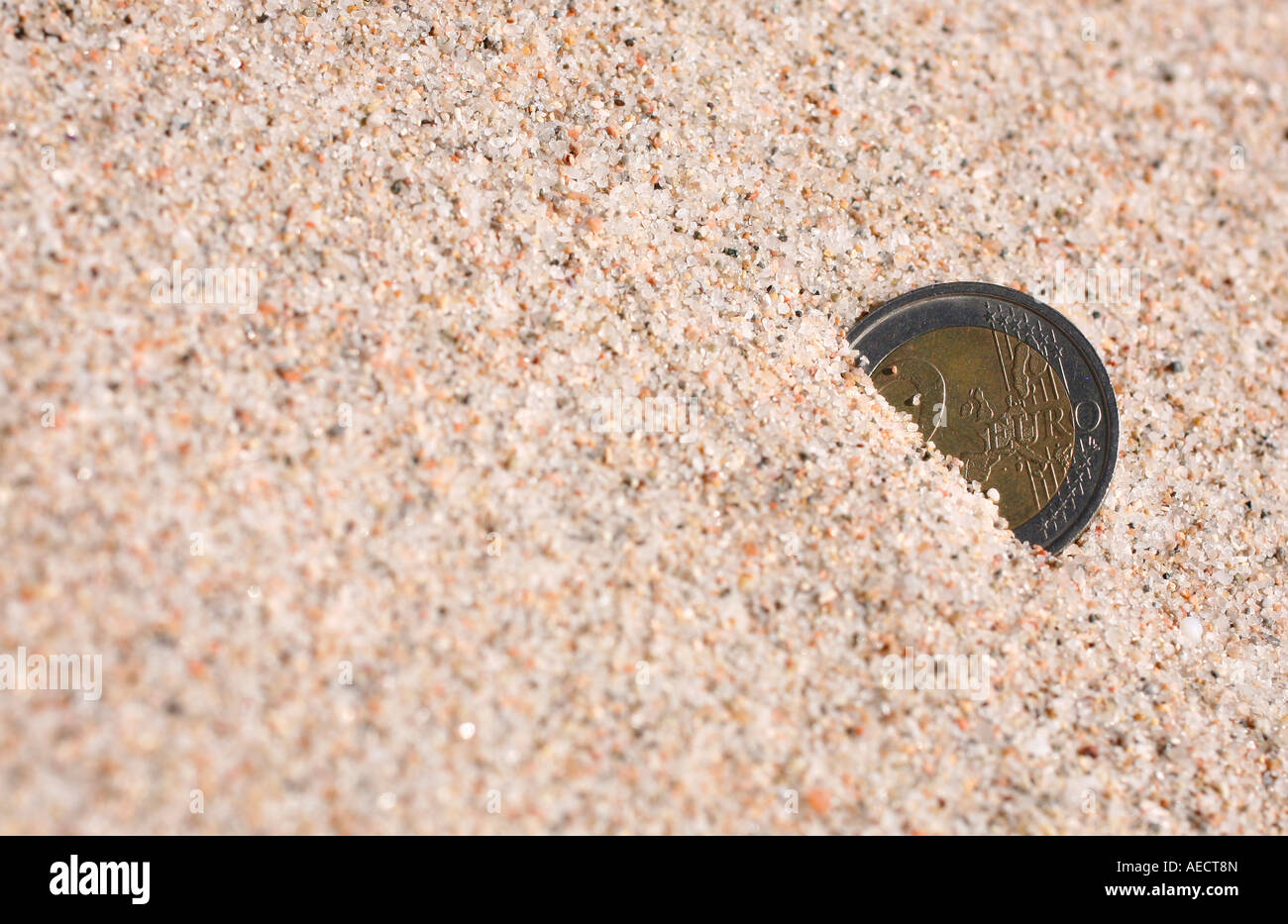 1 Euro coin buried in sand on beach Stock Photo - Alamy