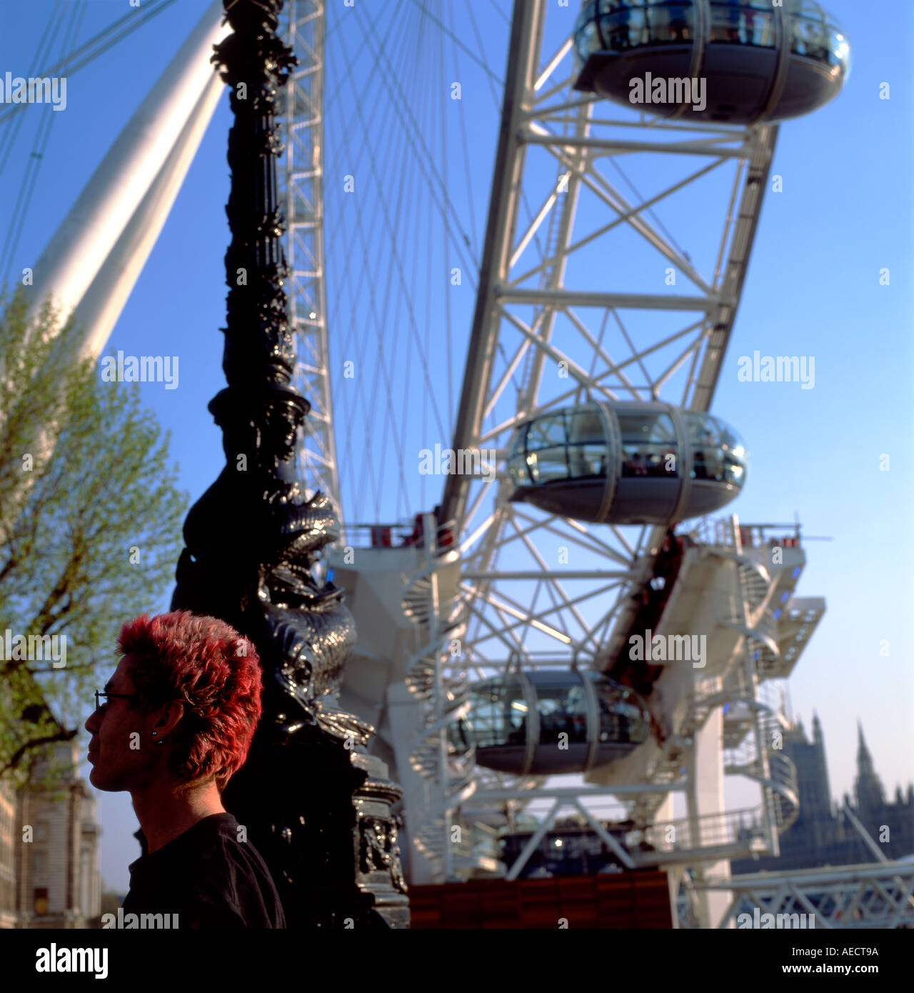 A man leaning against a lamp post on the South Bank of the River Thames ...
