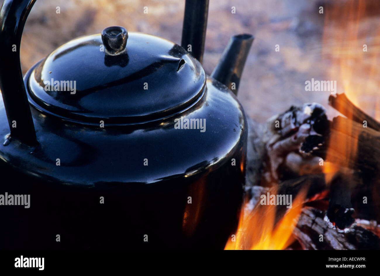 Close-up of black coffee kettle on burning camp fire boiling water ...