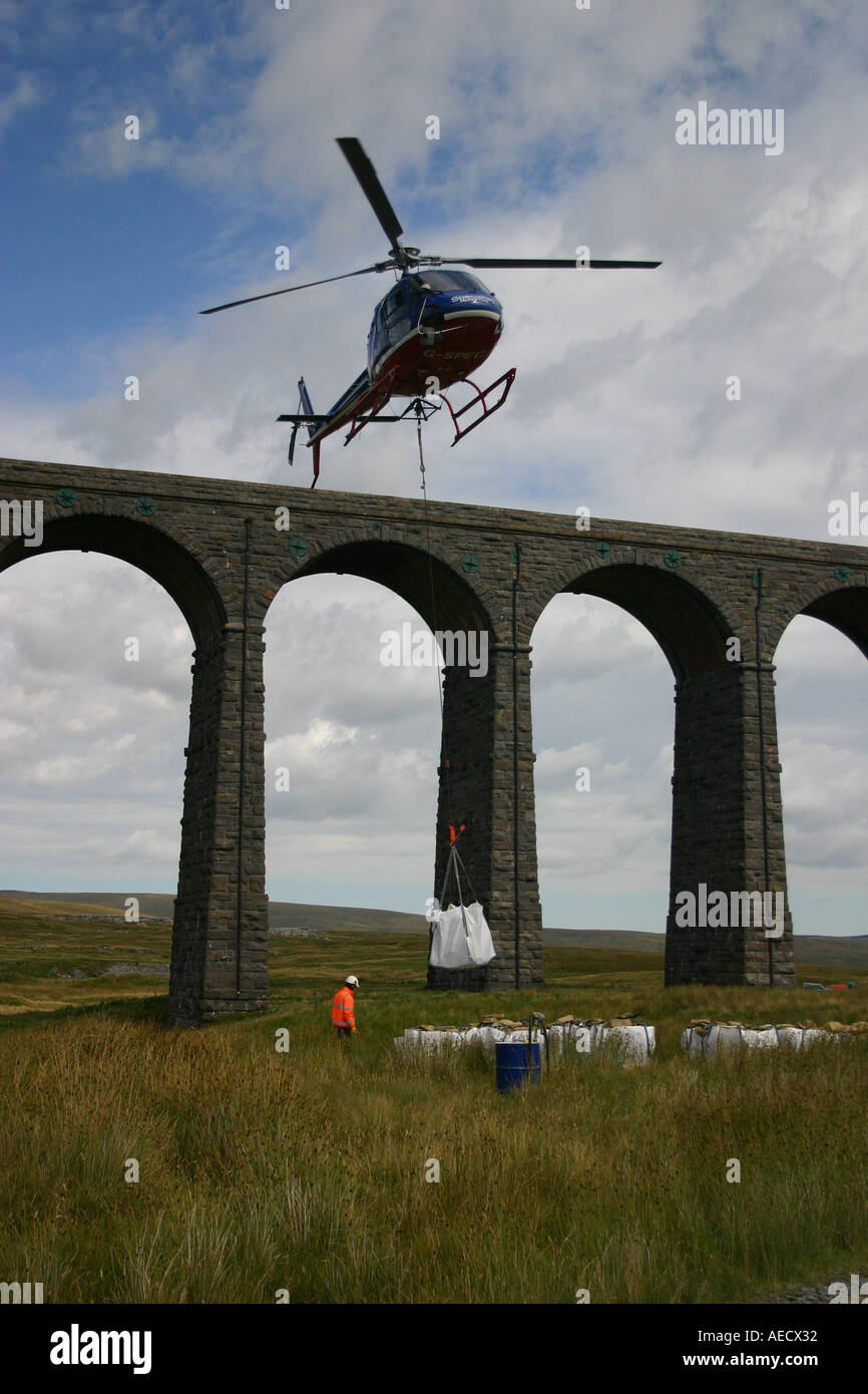 Helicopter transporting stone to repair footpaths Stock Photo - Alamy