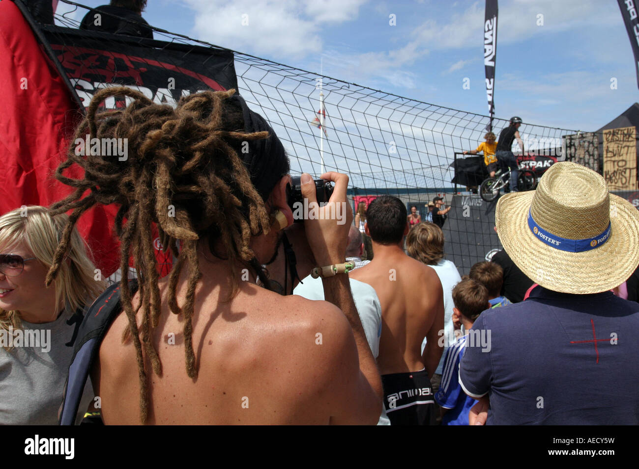 Man with dreadlocks photographing BMX bikers on vert ramp Rip Curl ...