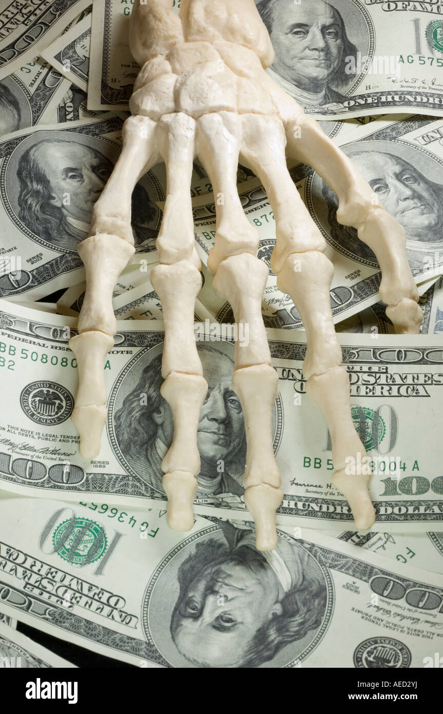 Skeleton hands prying dollar notes Stock Photo - Alamy