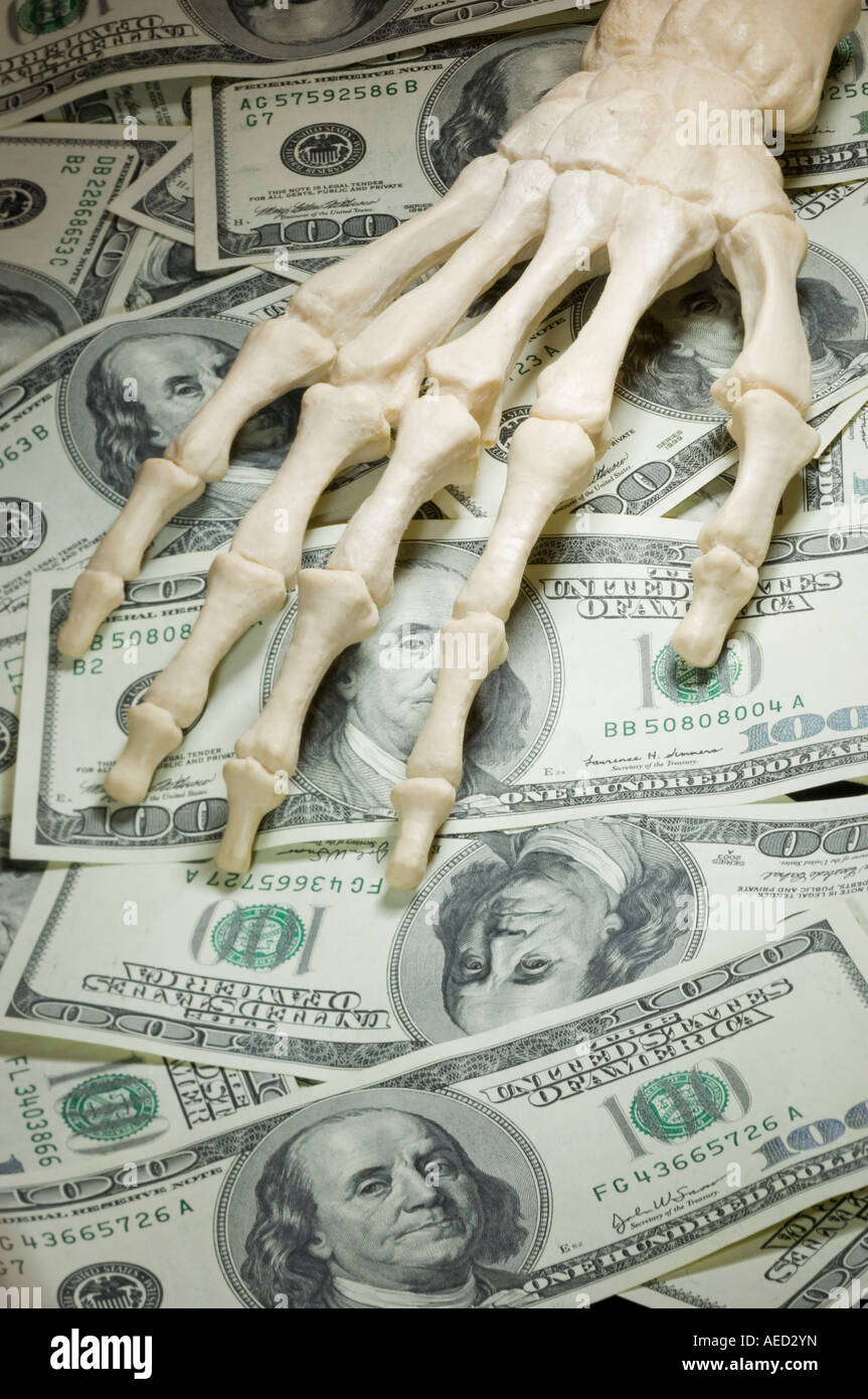 Skeleton hands prying dollar notes Stock Photo - Alamy