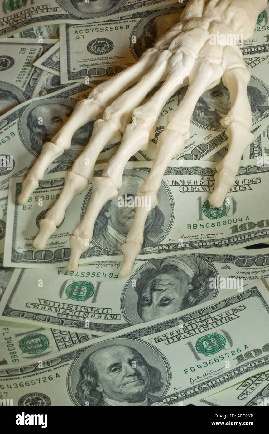 Skeleton hands prying dollar notes Stock Photo - Alamy