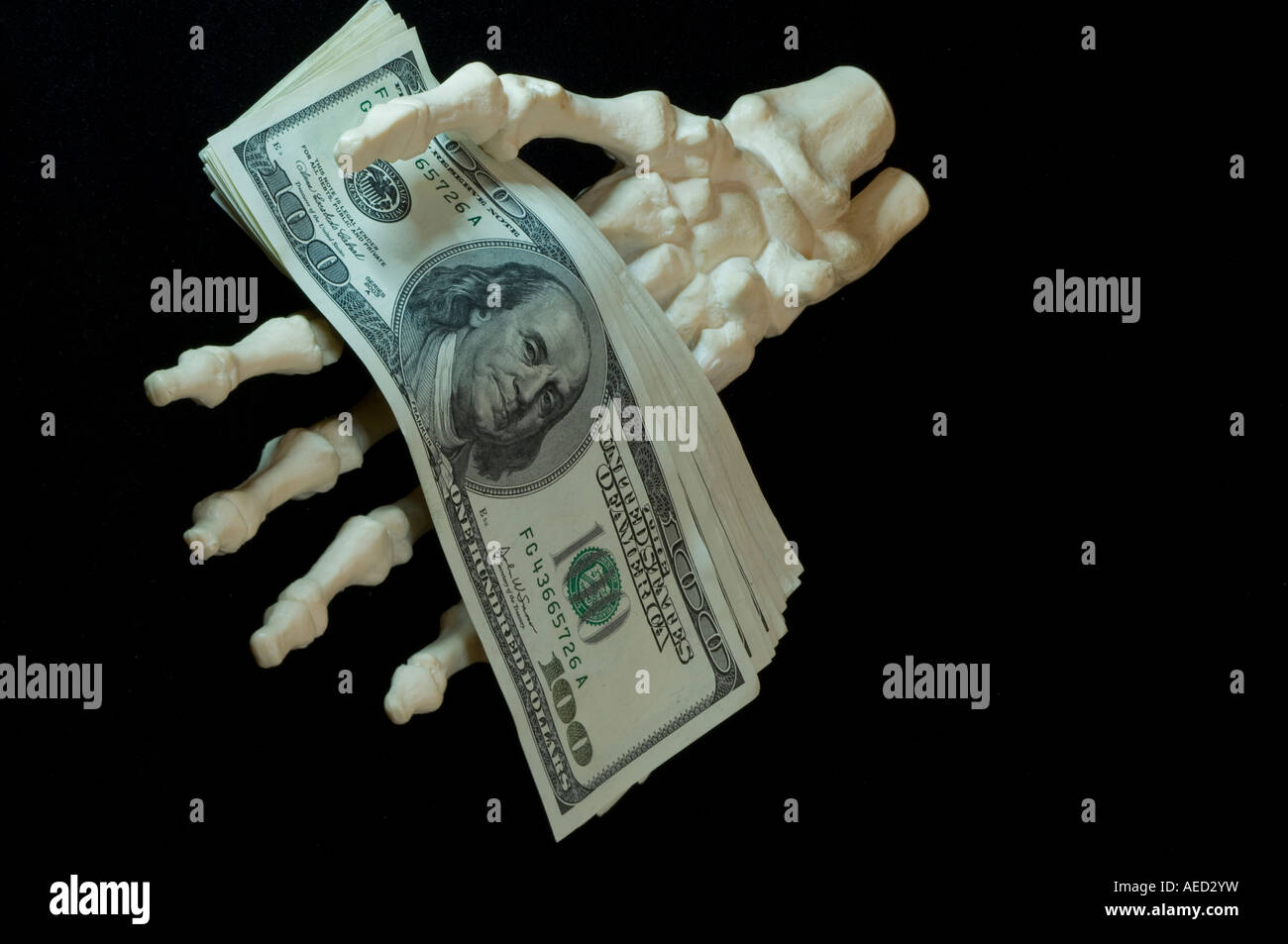 Skeleton hands prying dollar notes Stock Photo - Alamy