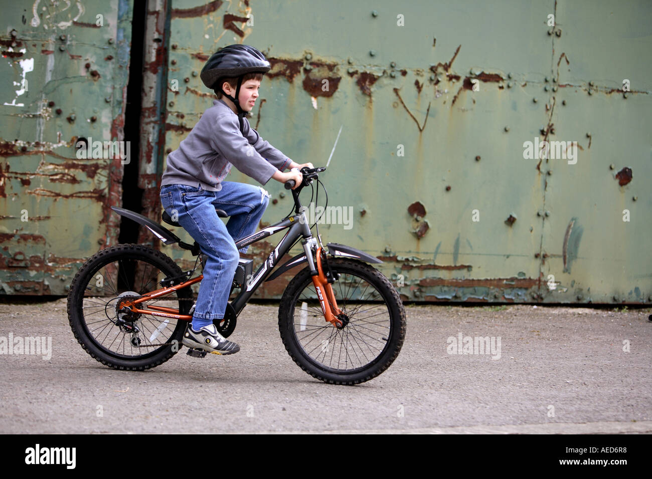 Horizontal environmental portrait of young boy riding his bike in ...