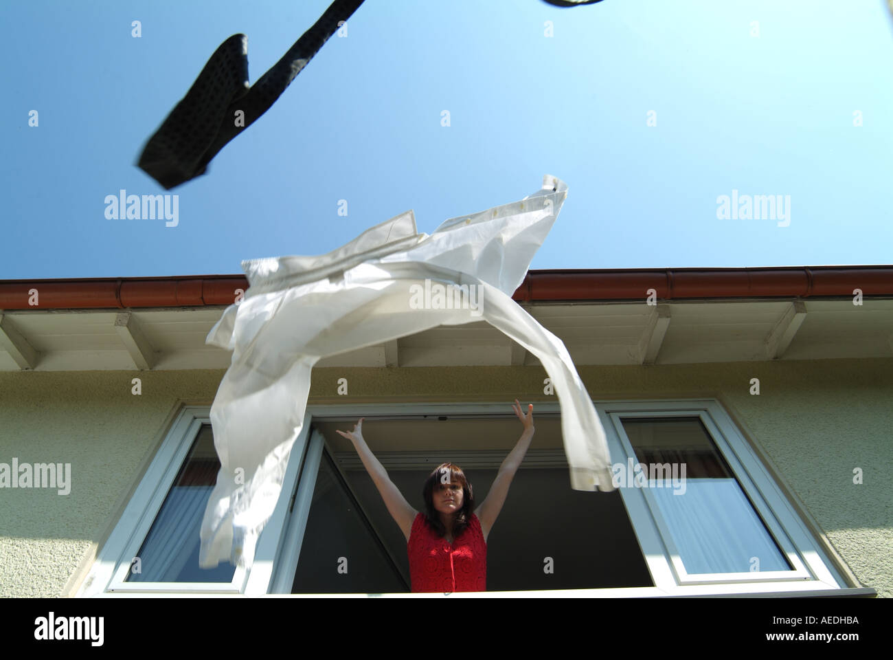 Woman throw clothes out of window hi-res stock photography and images ...