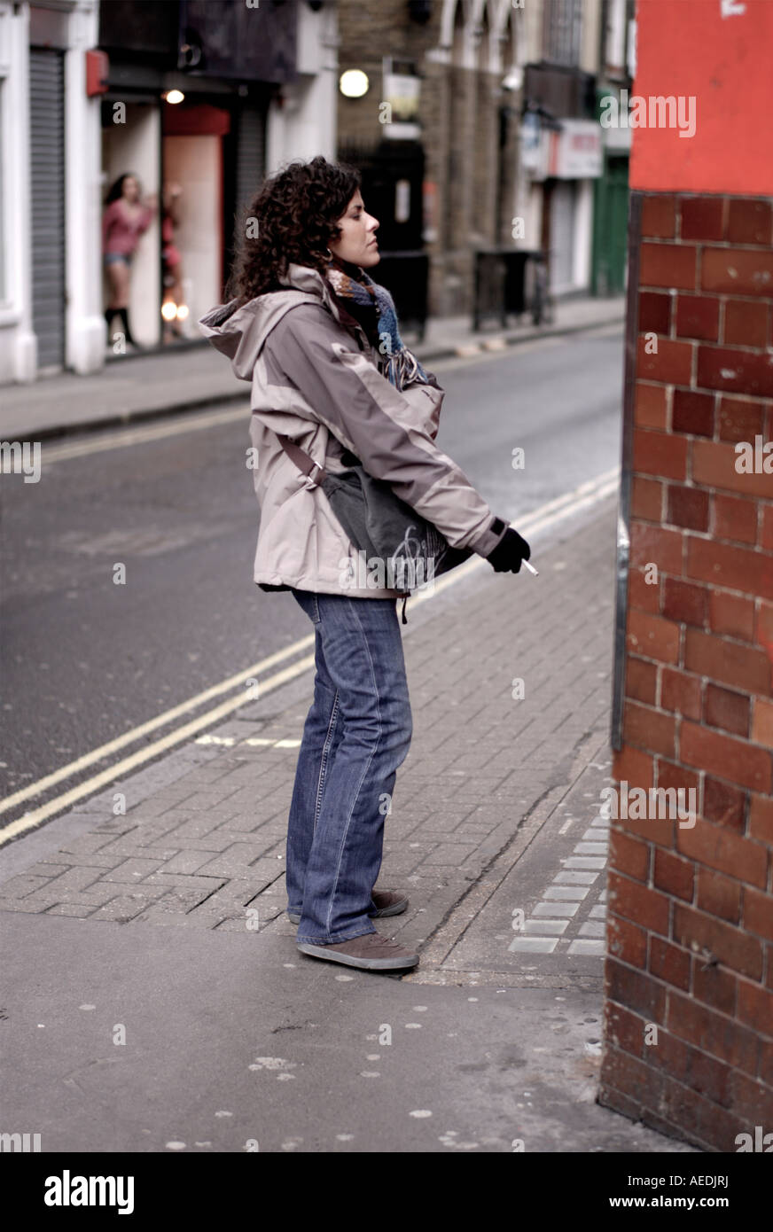 Woman windom shopping with cigarette with ominous figure in distance ...