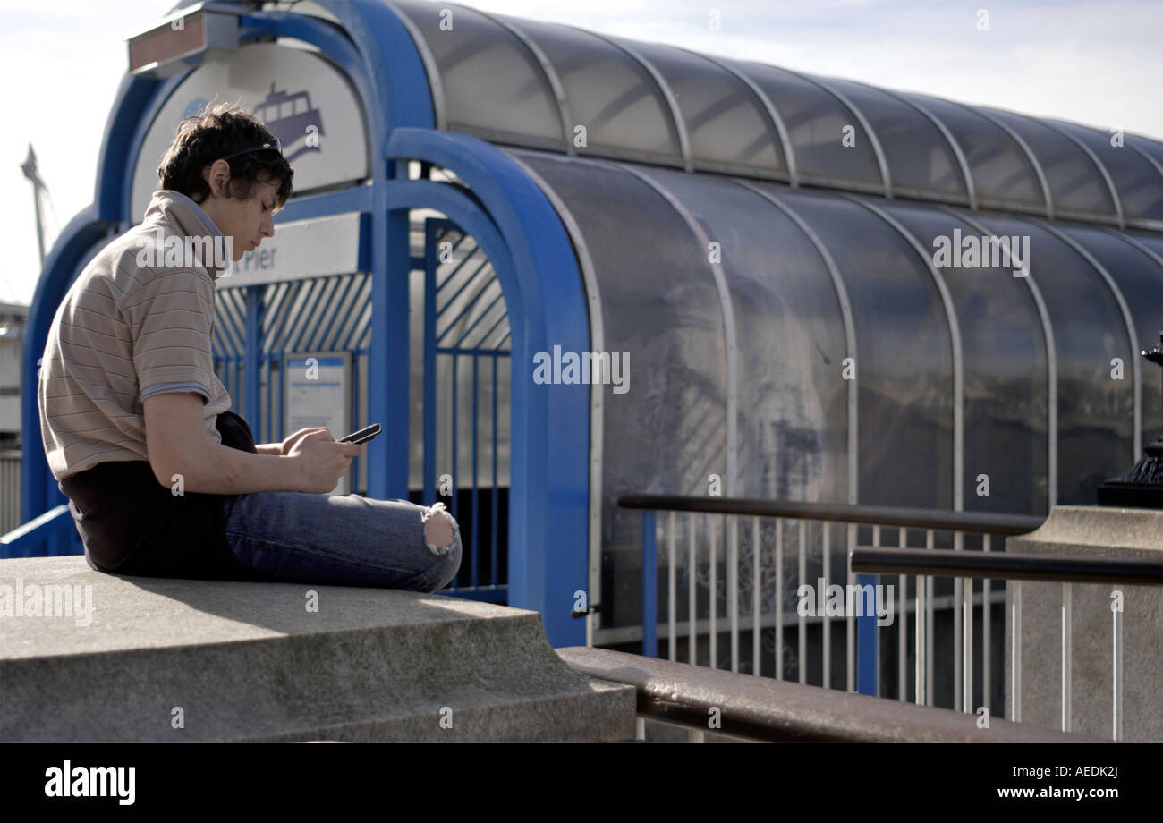 Boy sat texting Stock Photo - Alamy