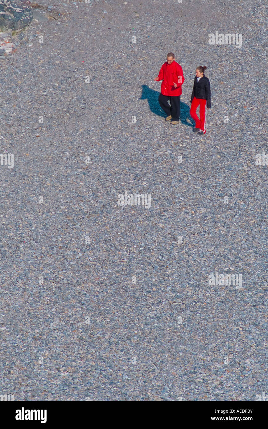 Couple wearing red and black on sandy beach Stock Photo - Alamy