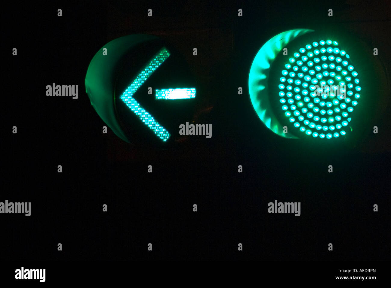 Illuminated green street light with arrow Stock Photo - Alamy