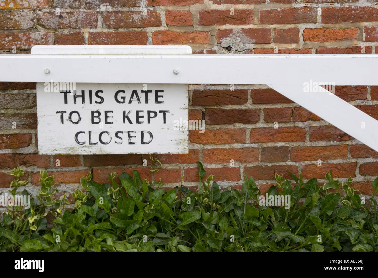 Sign stating gate to be kept closed affixed to an open gate Stock Photo ...