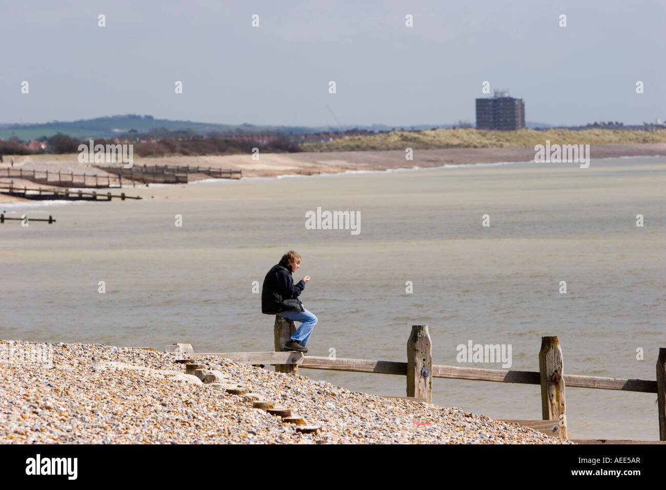 The beach in Climping West Sussex with single man sitting alone on ...