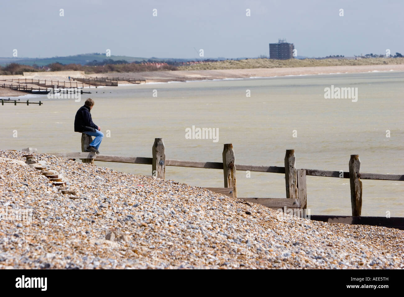 The beach in Climping West Sussex with single man sitting alone on ...