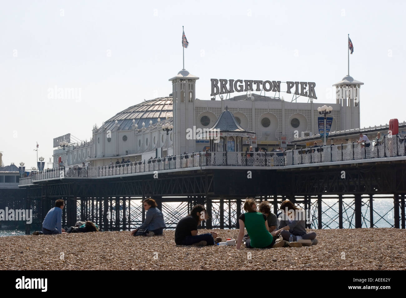 A busy and crowded Brighton beach and pier on an unseasonably warm day ...