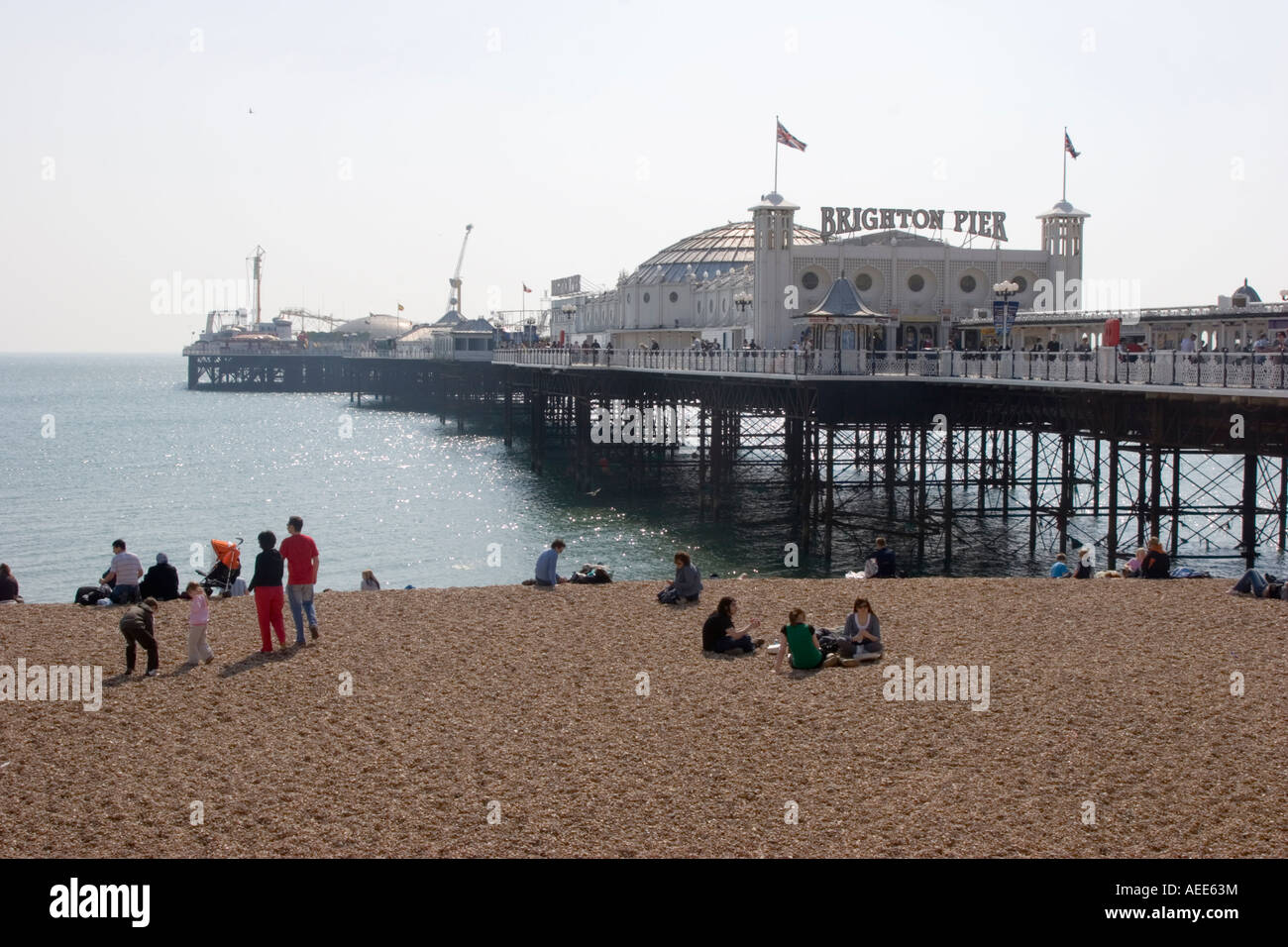 A busy and crowded Brighton beach and pier on an unseasonably warm day ...