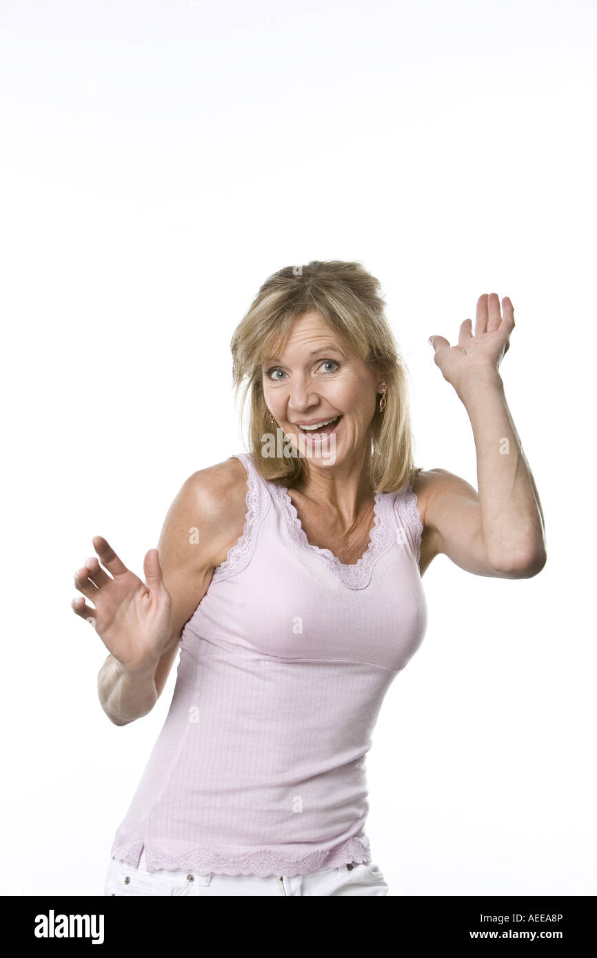 A portrait of a happy woman in her 40's wearing a pink top smiling and ...